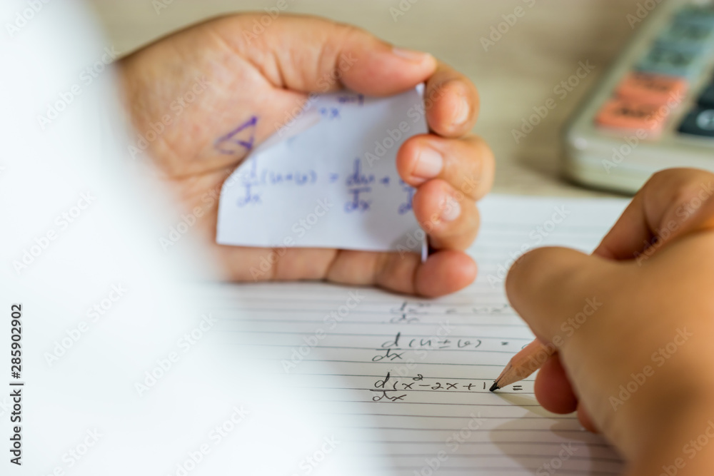 Student using formula math sheet to cheat on test. Hand of university ...