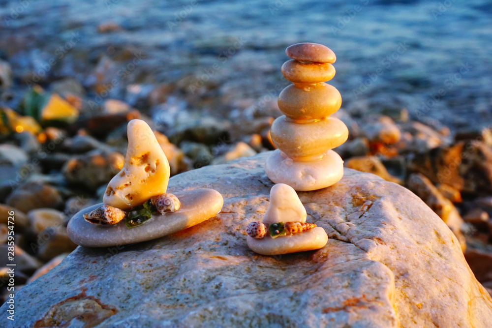Sunset reflection on the sea beach with pebble art, small stacking ...