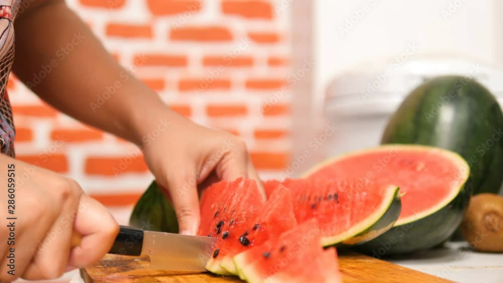 close up hand using small knife sliced water melon into piecs on the ...