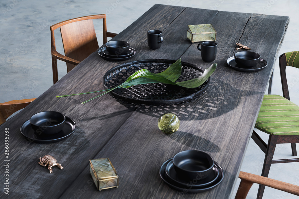 Close up of design craft oak table with cups of coffee, plates and ...