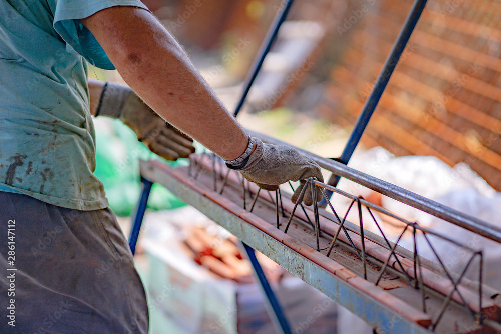 Construction worker holding carry lattice girder and truss girders ...