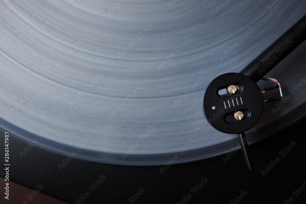 Modern round headshell with black cartridge on straight tonearm and ...