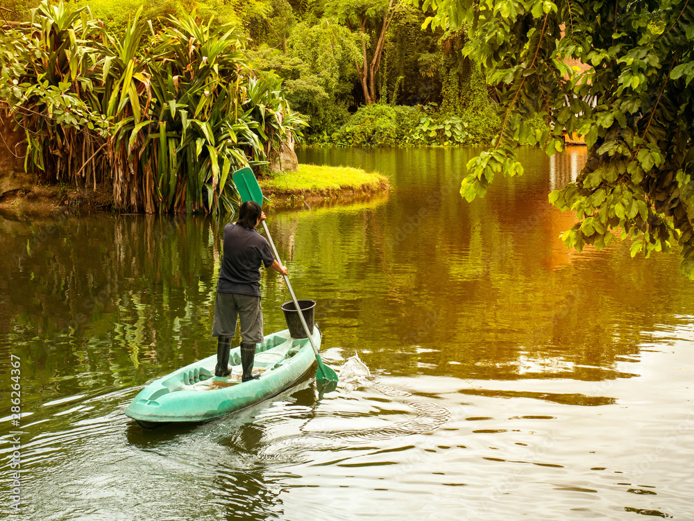 The back of the worker are rowing to feed the animals in the zoo. Stock ...