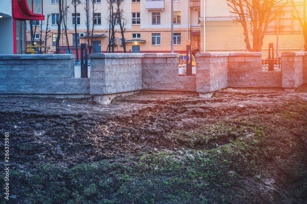 Cracked earth on the mountainside. Landslide near the concrete fence ...