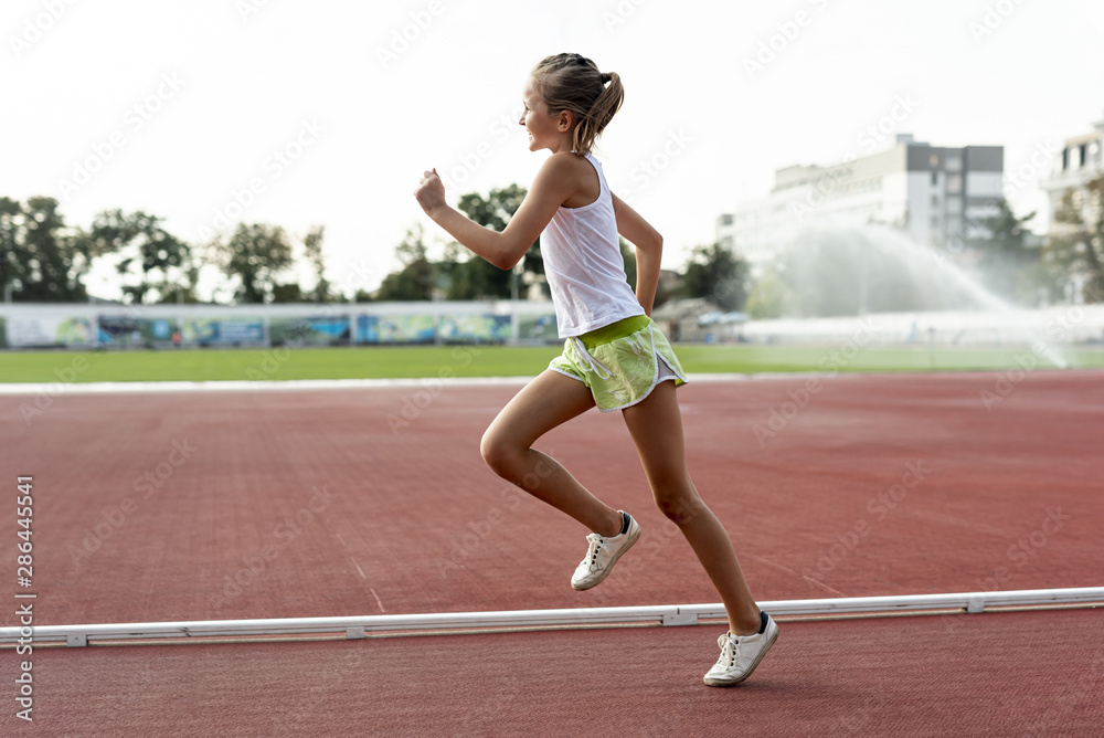 Side view of girl on running track Stock Photo | Adobe Stock