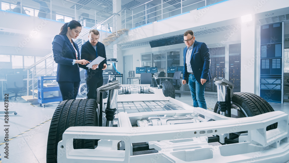 Automotive Design Engineers Talking while Working on Electric Car ...