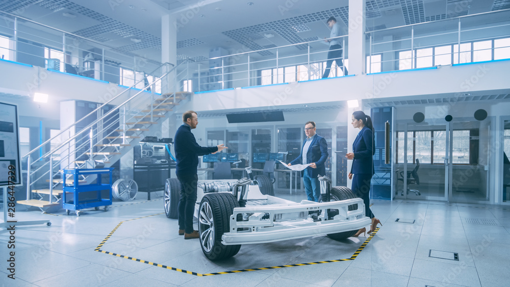 Automotive Design Engineers Talking while Working on Electric Car ...