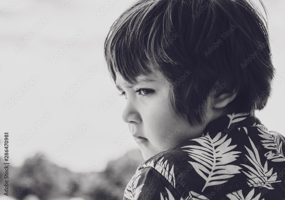 Emotional portrait of little boy lookig down with sad face, Side view ...