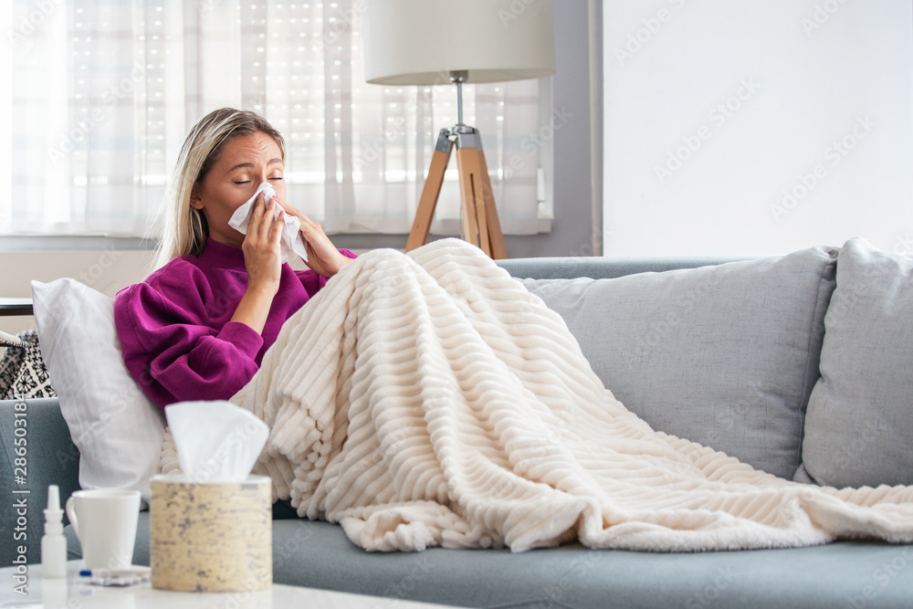 Sick woman with headache sitting under the blanket. Sick woman with ...