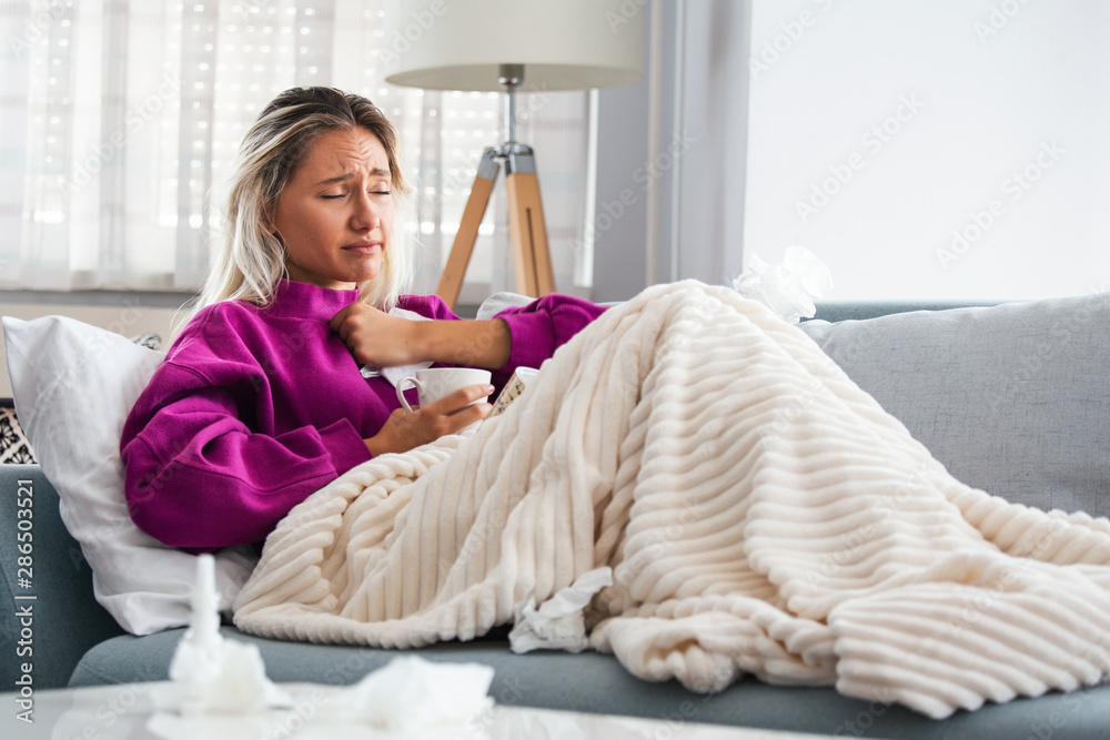 Sick day at home. Blonde woman has runny and common cold. Cough ...