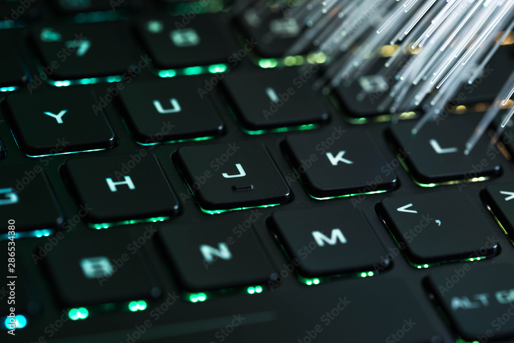 Optical fibres over colorful rgb gaming laptop keyboard close up shot ...