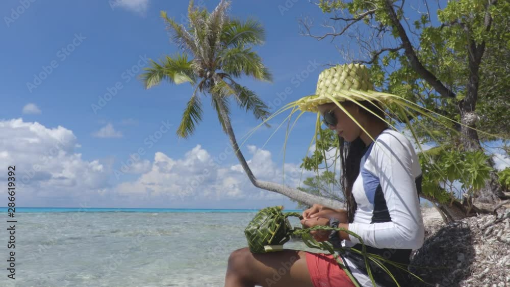 French polynesia - woman weaving a purse out of palm leaves on ...