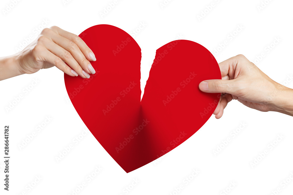 Male and female hands tearing a red heart symbol of love in half ...