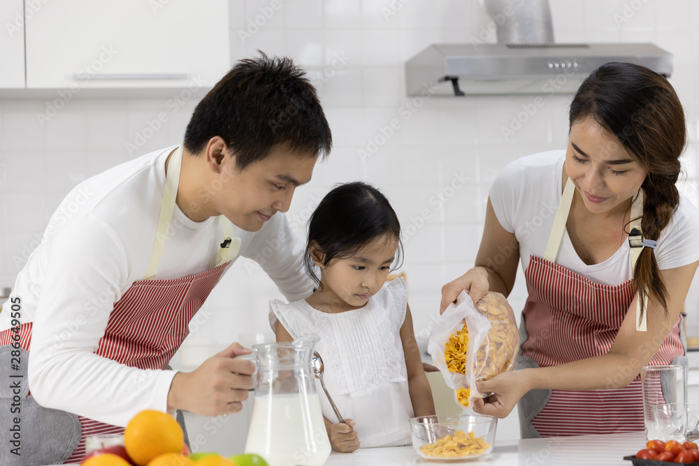 Happy Asian family make a cooking. Father and Mother make breakfast ...