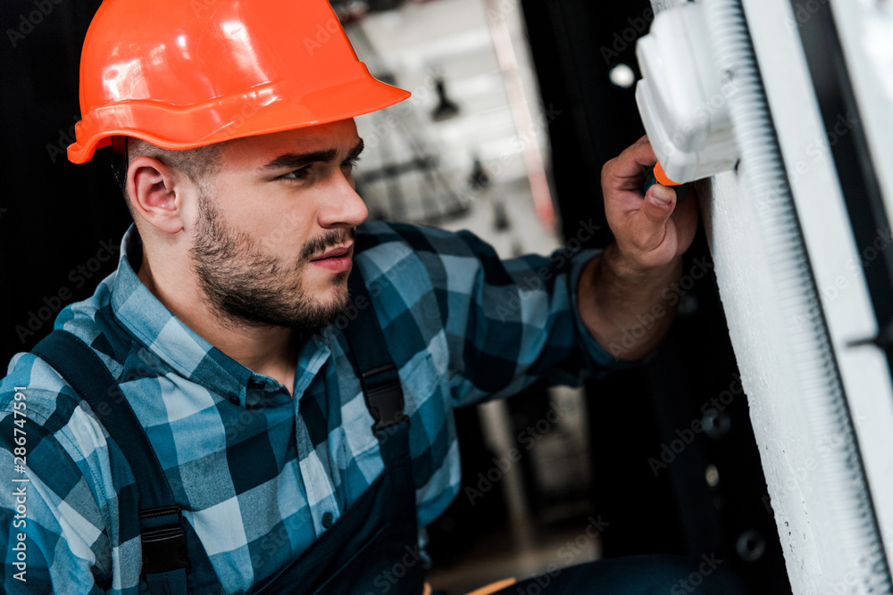 handsome workman in safety helmet touching light switch Stock Photo ...