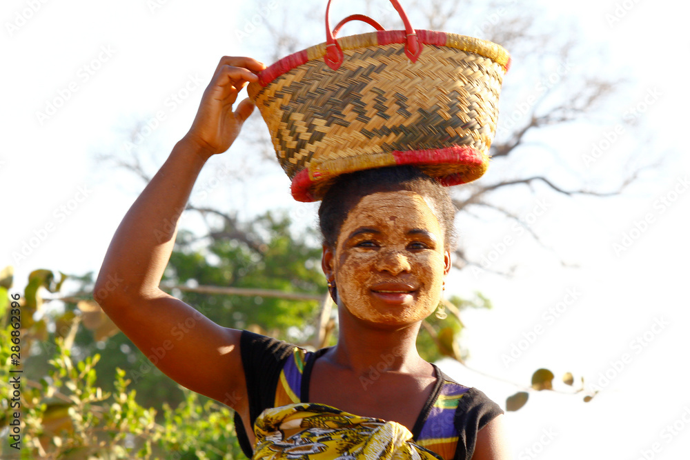 Portrait of Malagasy woman with traditional mask on the face ...