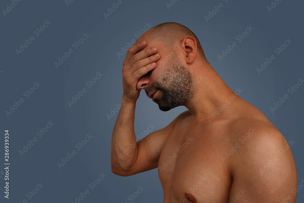 dark-skinned man with a bare-chested athletic build covered his face ...