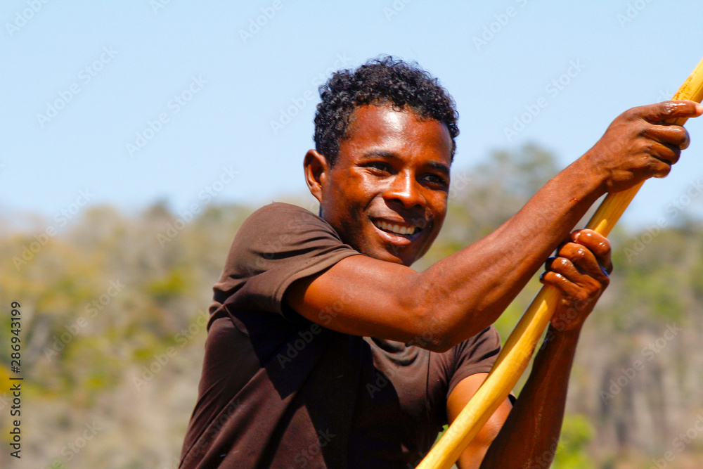 Young Malagasy rafter man rowing traditional canoe on river, Madagascar ...