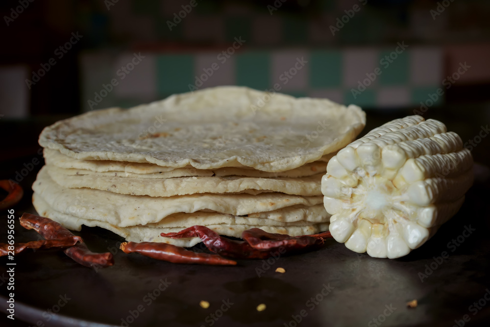 En la mesa de la cocina hay muchas tortillas de maíz y algunos pedazos ...