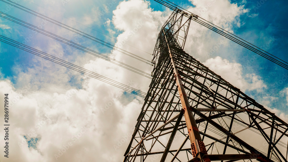 Electricity pylons with blue sky and white clouds. High voltage grid ...
