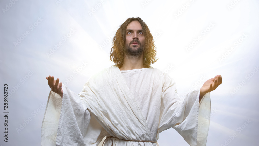 Jesus raising hands to heaven on illuminated background, Resurrection ...