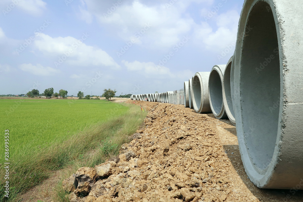 Concrete drainage pipes stacked for road construction site, Concrete ...