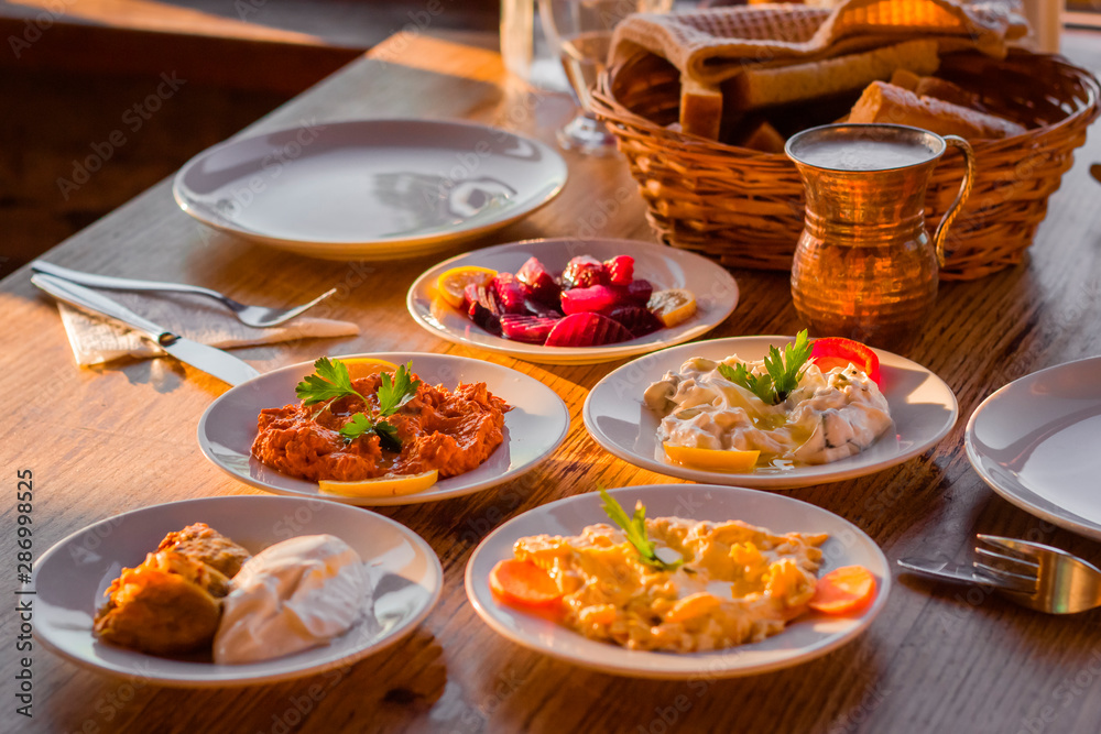 traditional turkish appetizers on table in evening sun light and ayran ...