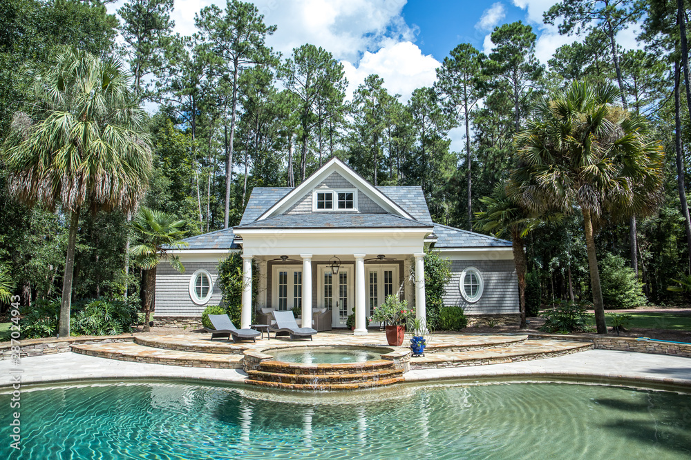 Custom pool House behind a landscaped estate with a large swimming pool ...