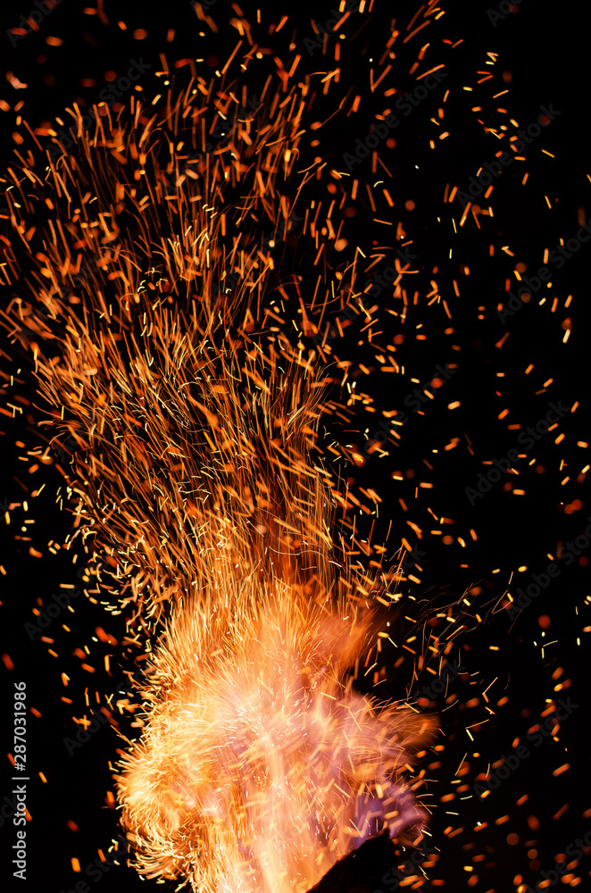 Flame of fire with flying burning red sparks on a black background ...