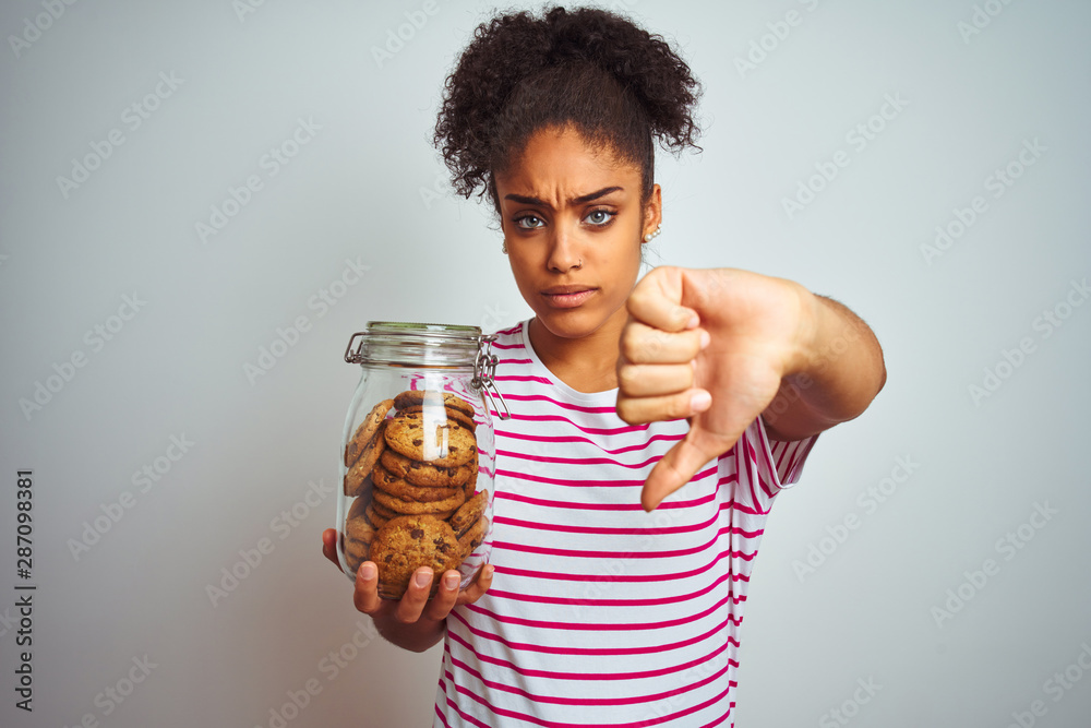 Young african american woman holding a jar of cookies over isolated ...
