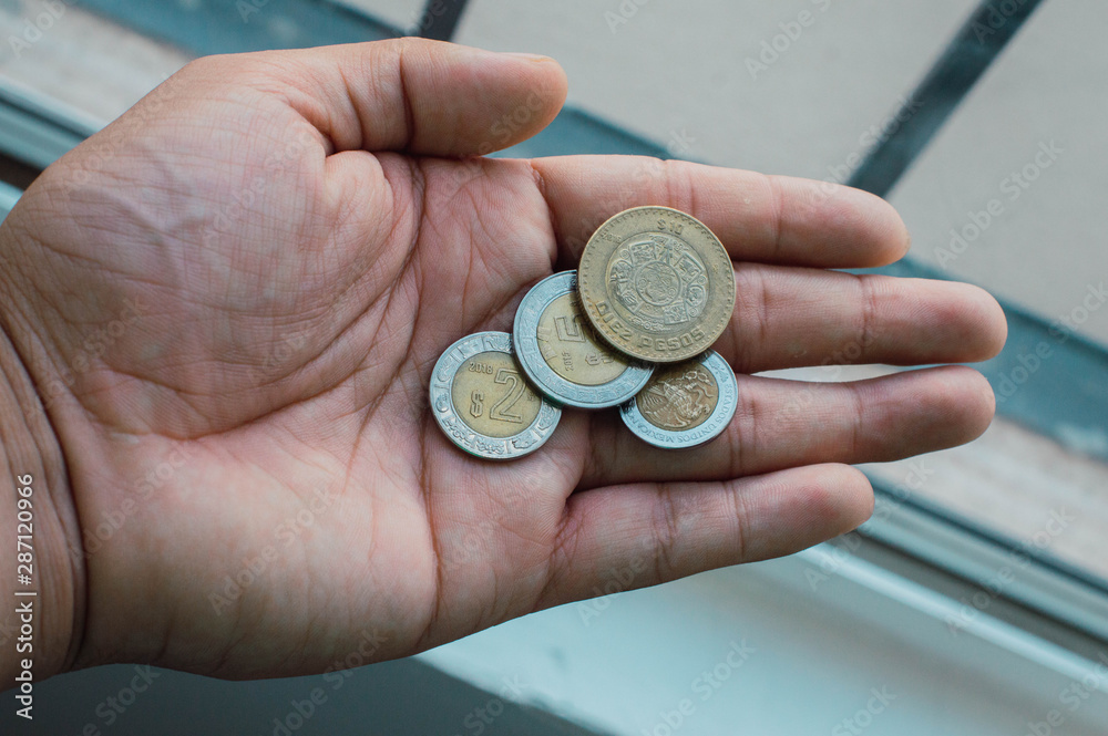 Monedas en la palma de la mano. Pesos mexicanos sobre la mano de hombre ...