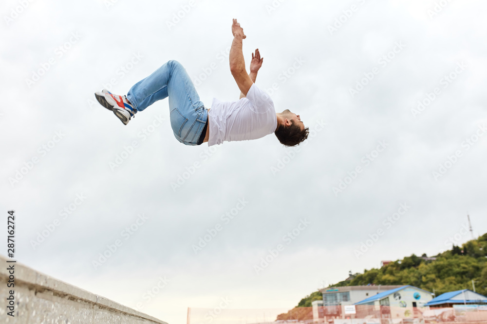 ambitious gymnast turning a somersault, full length side view photo ...