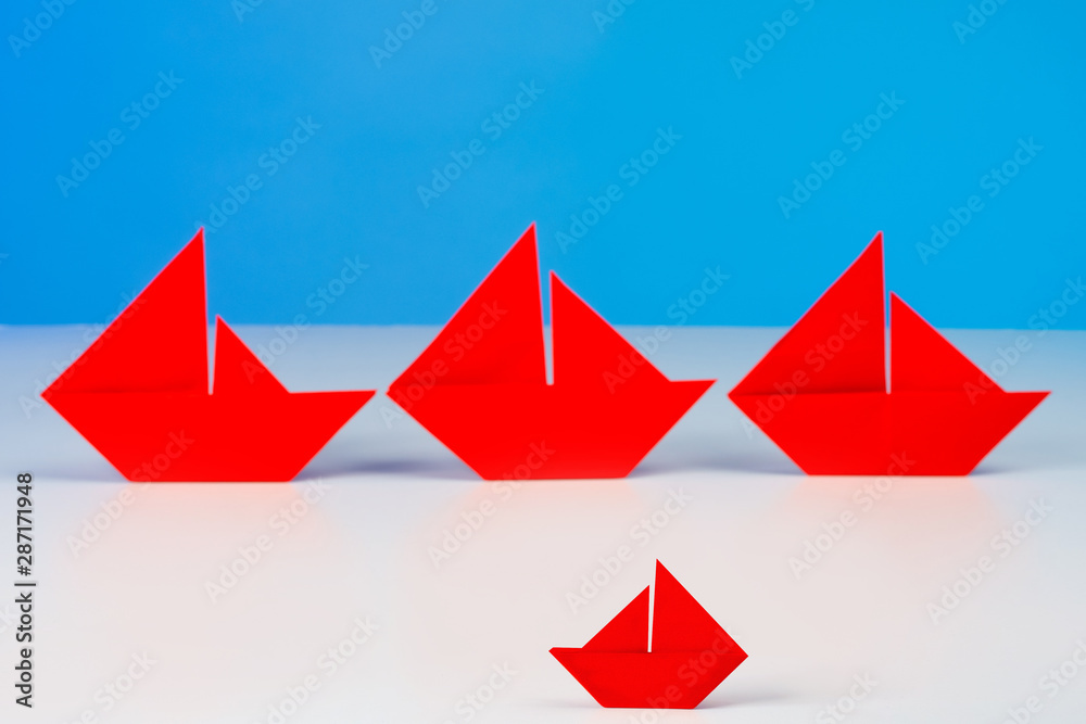 Red paper boats of different sizes. Origami. A symbol of inner freedom ...