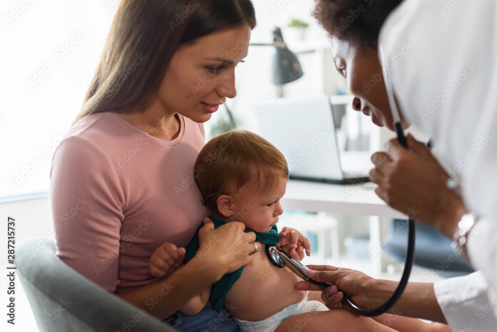 Mother and her baby, visiting the doctor for a medical examination ...