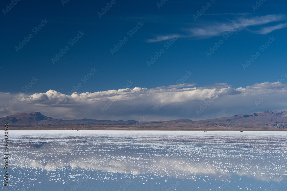 The beauty of the salt flats reflecting the clouds and mountains after ...