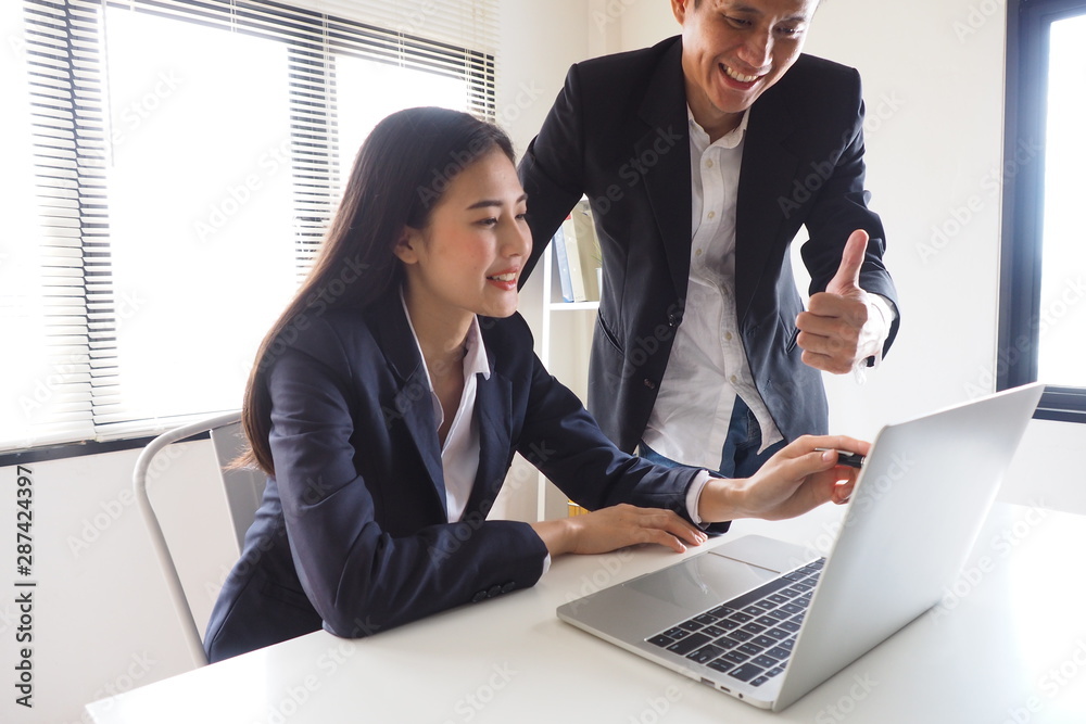 Boss giving thumbs up to his female colleague while giving advice and ...