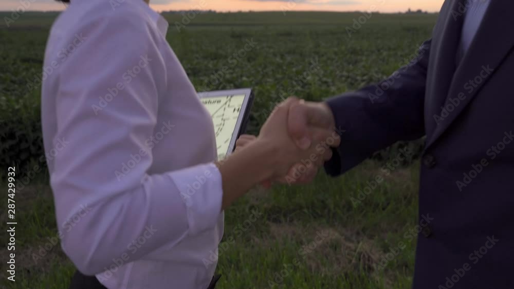Man and woman shaking hands agreement for agricultural land with blue ...