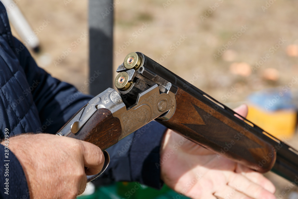 Charging a hunting rifle. Male hunter charges a double-barreled shotgun ...