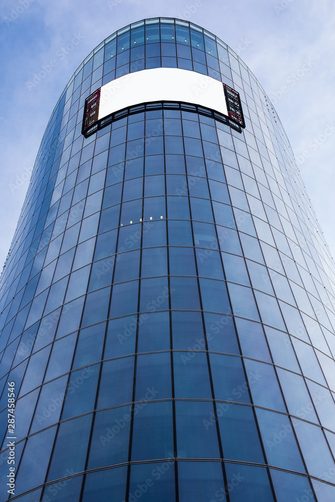 Bottom view of a modern skyscraper building with advertising board with ...
