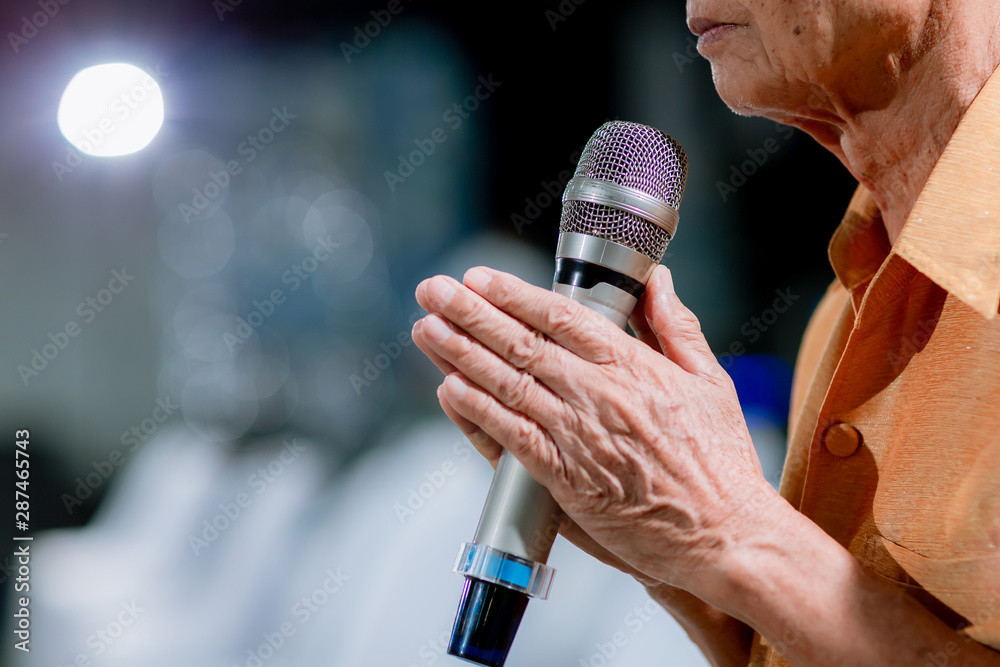 Foto de Man holding microphone with two hands. Two hands holding the ...
