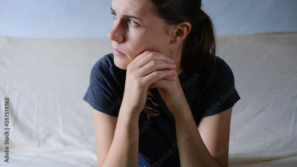 Close up desperate woman sit on sofa looking away feel depressed ...