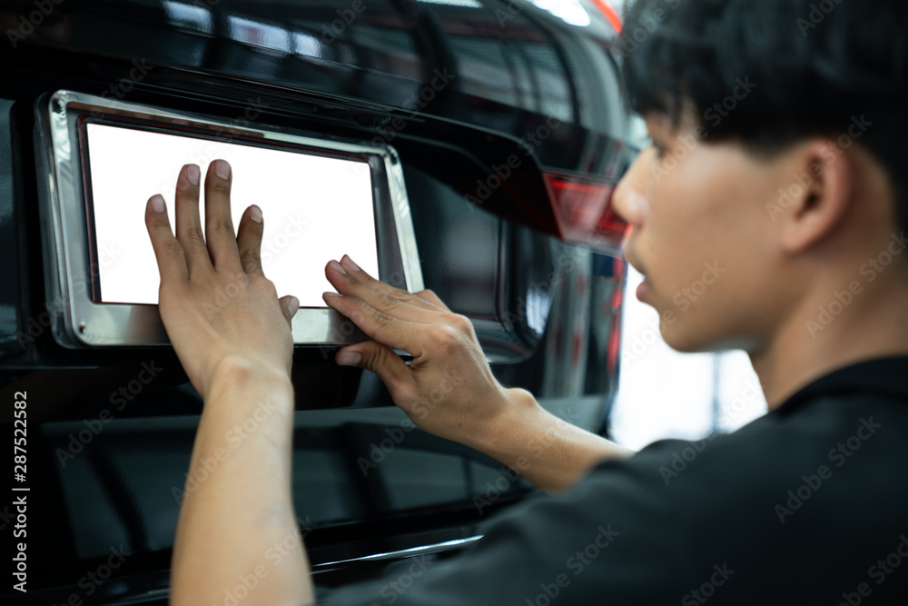 Asian man installing the licence plate of a car. Technician installing ...