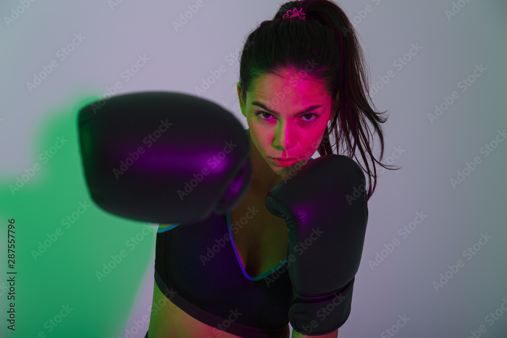 Beautiful strong fitness woman boxer isolated with led flash lights ...