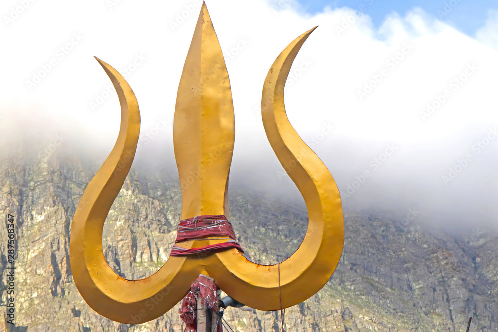 Trident weapon of lord shiva placed ahead of a cloudy mountain-image ...