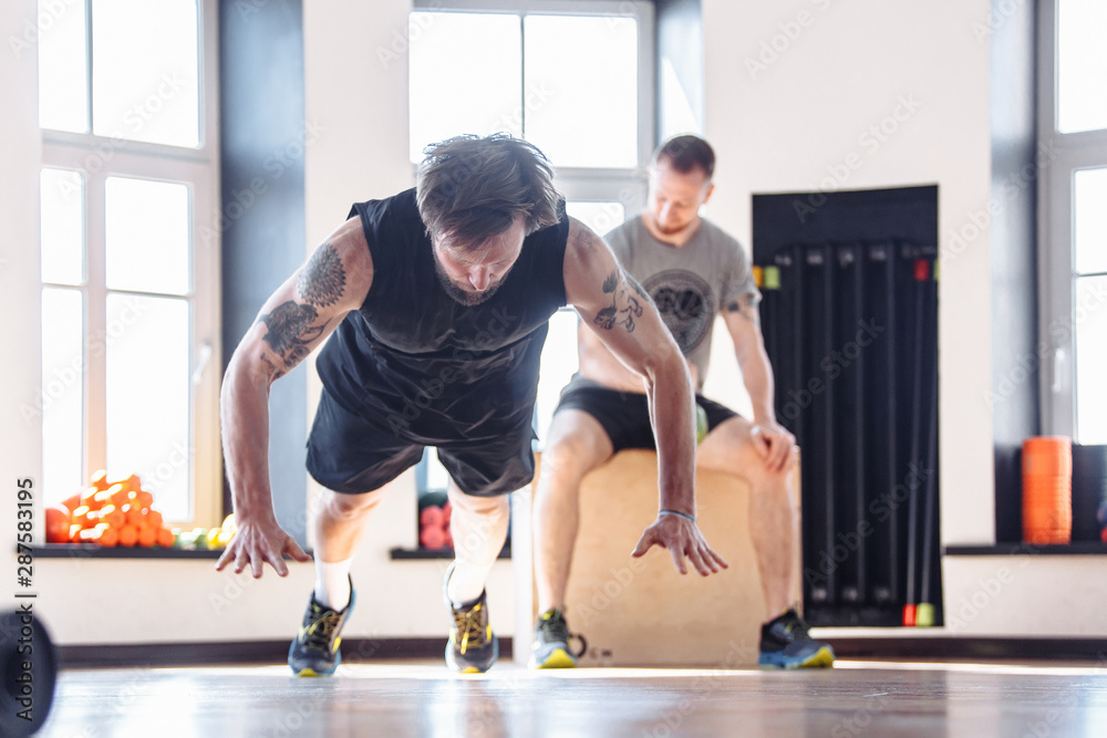 Two friends of men athletes doing strength training and interval ...