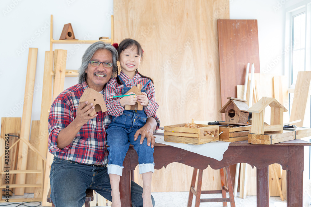 Asian carpenter and his daughter are designing and creating wooden ...