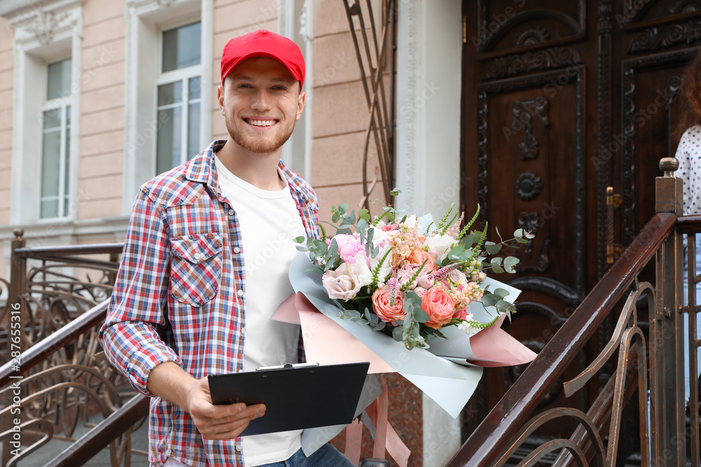 African-American woman receiving flower bouquet from delivery man at ...