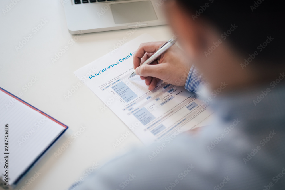 Man holding hand filling car motor insurance claim form male ...