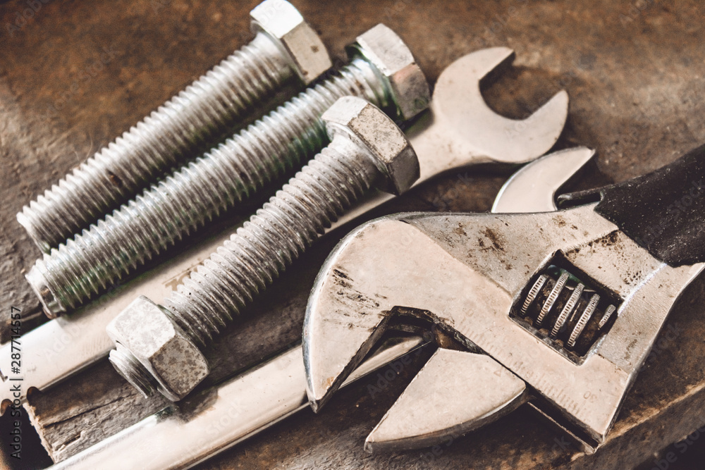 Tools for the job. Bolts and nut with wrench are on the table. Stock ...