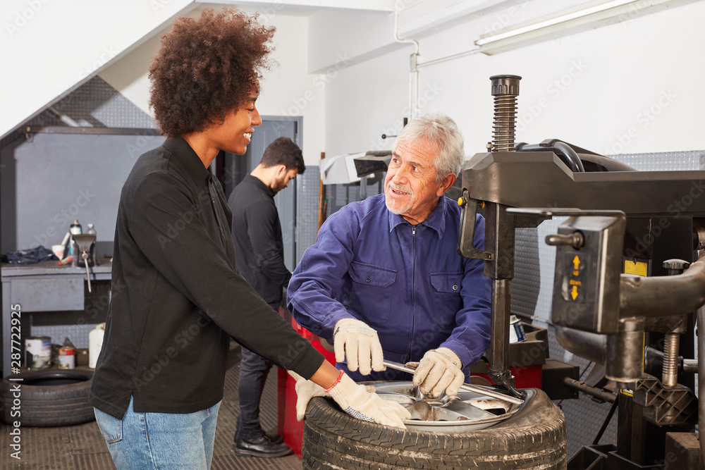 Foto de Ausbilder in der Auto Werkstatt mit Frau als Lehrling do Stock ...